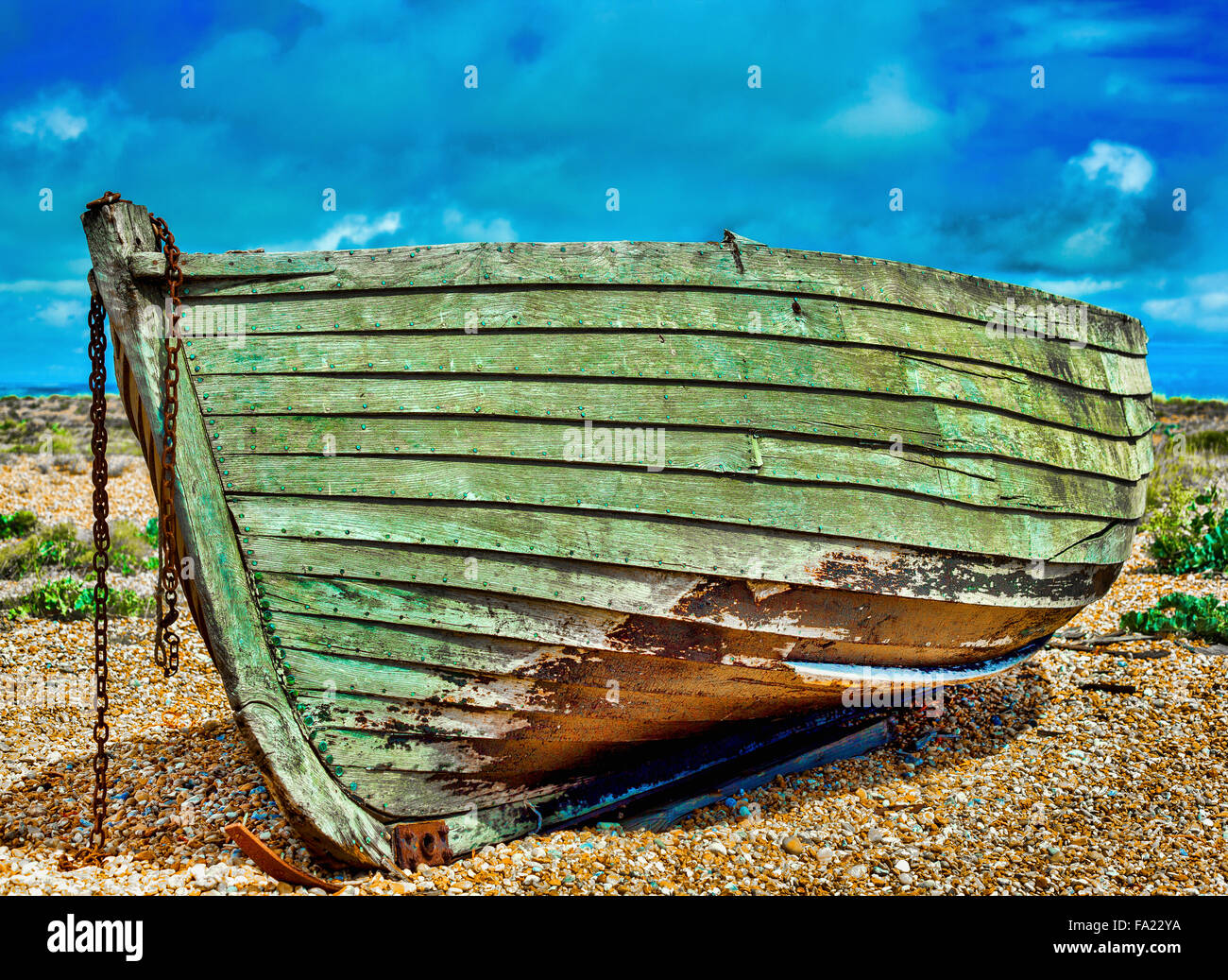 Old wooden fishing boat on a pebble beach Stock Photo - Alamy