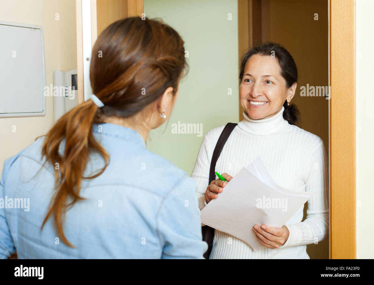 woman filling questionnaire for employee with paper at door Stock Photo ...