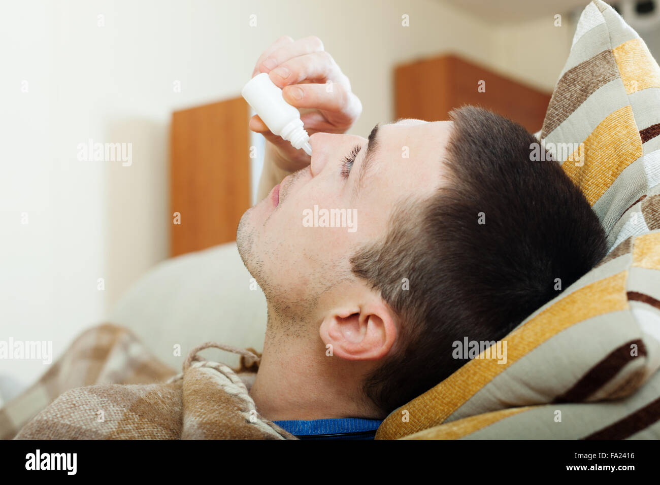 Man dripping nasal drops in home Stock Photo - Alamy