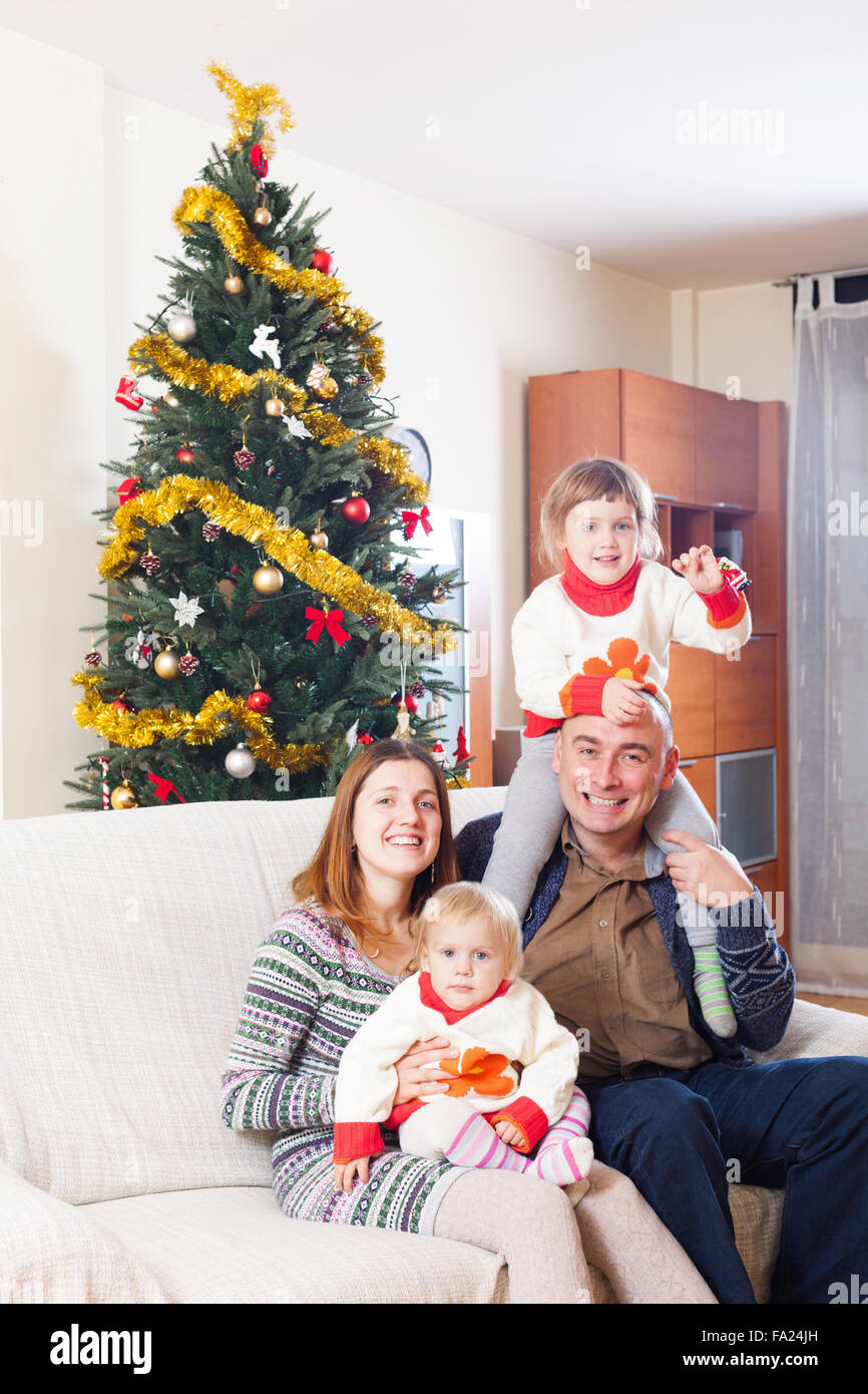 Smiling family near Christmas tree at home Stock Photo - Alamy