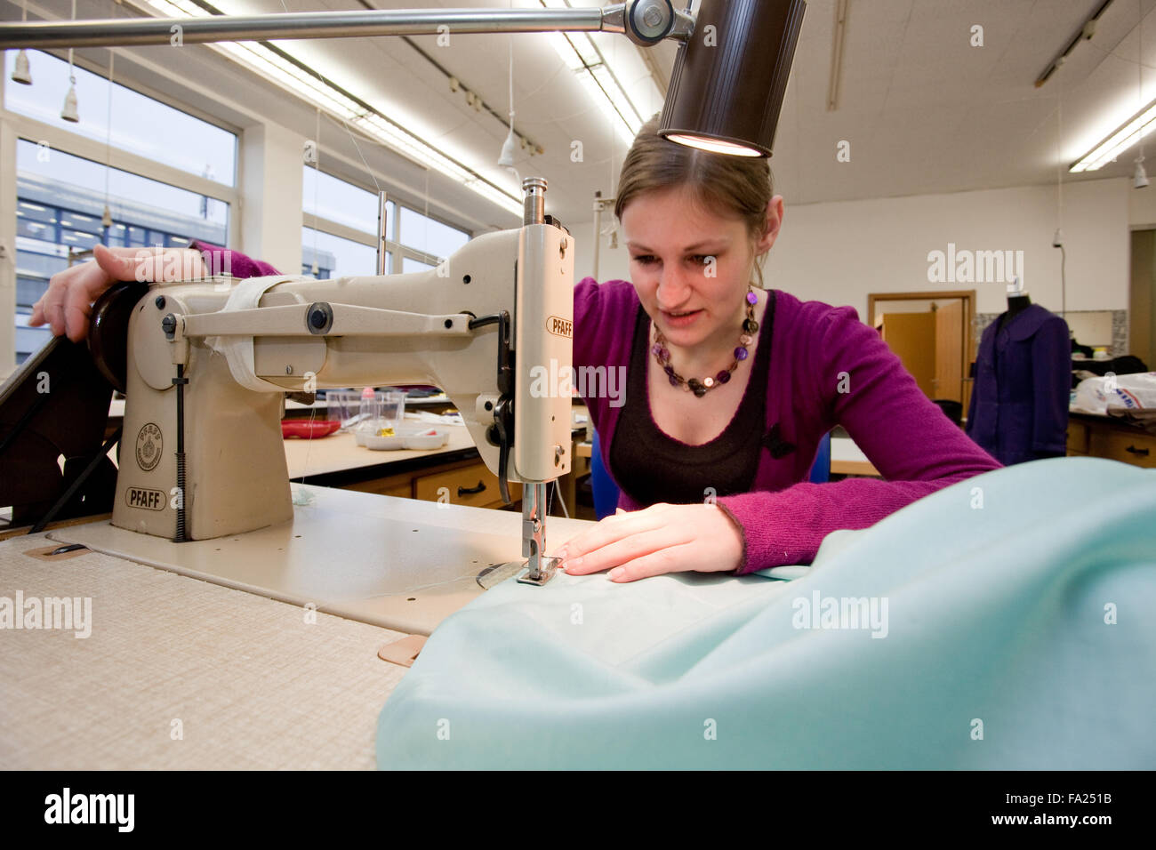 Custom tailor works at a sewing machine Stock Photo - Alamy
