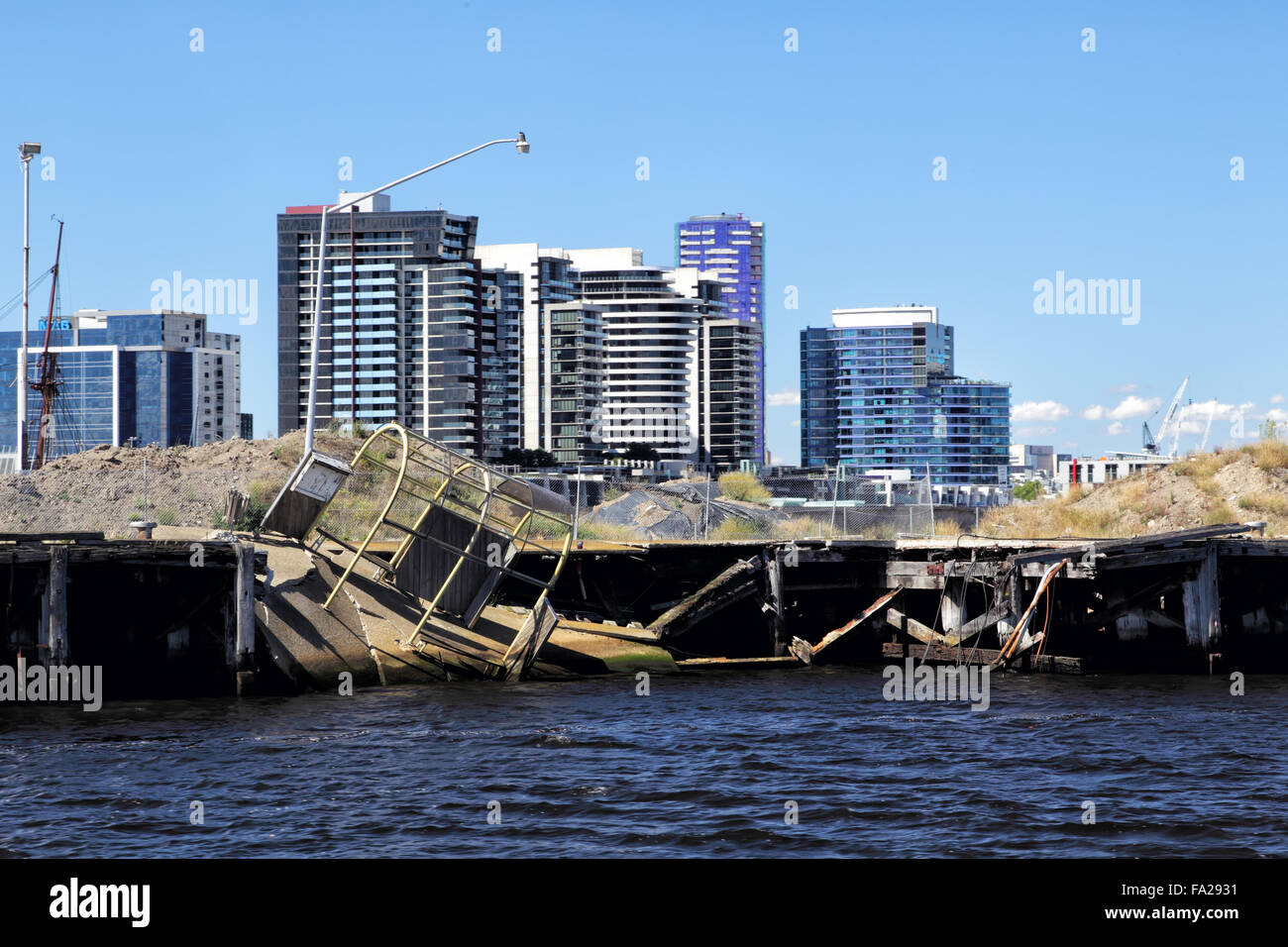 Modern high-rise buildings behind a run-down stretch of river bank of ...
