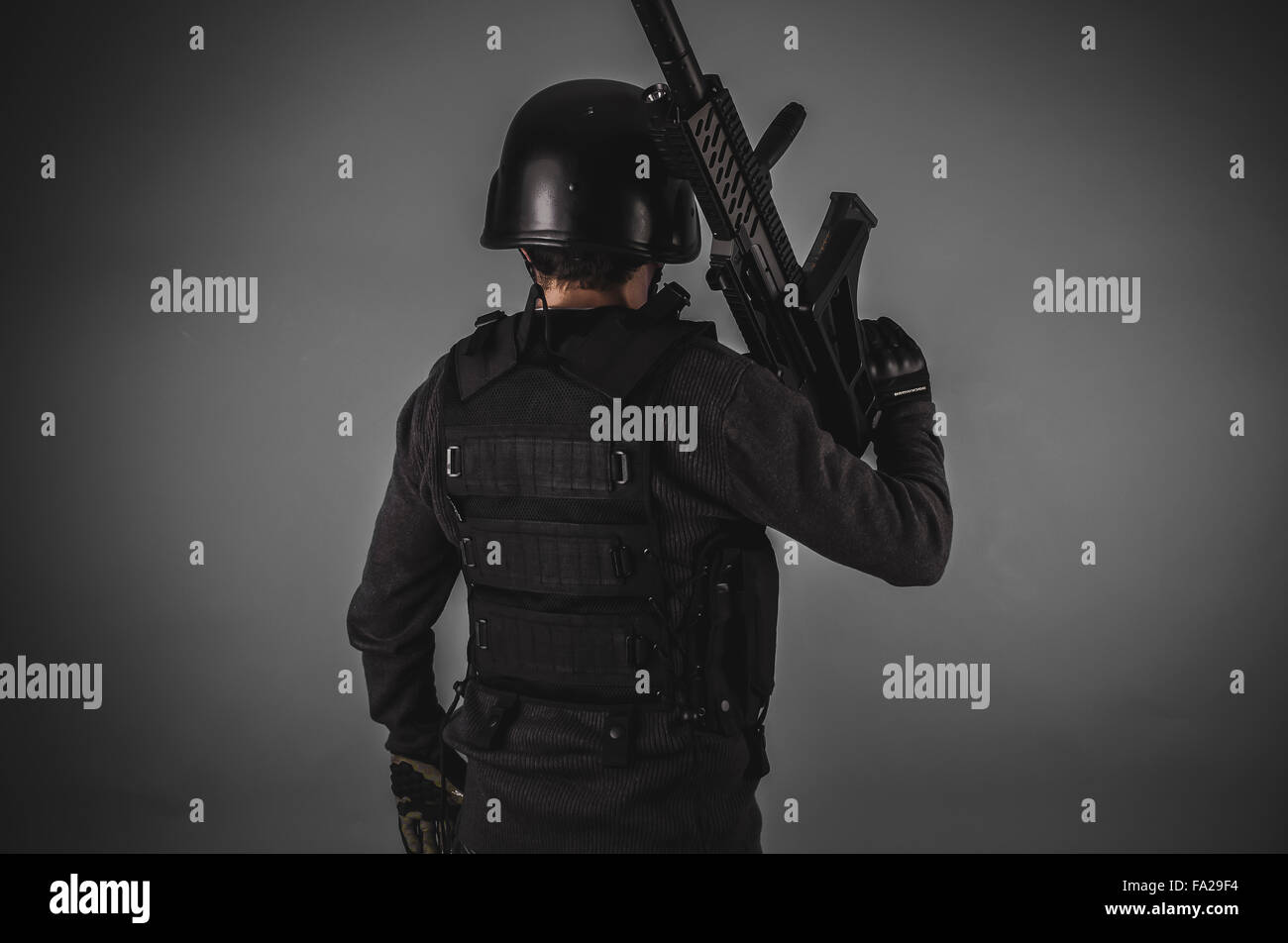 forces, airsoft player with gun, helmet and bulletproof vest on gray ...