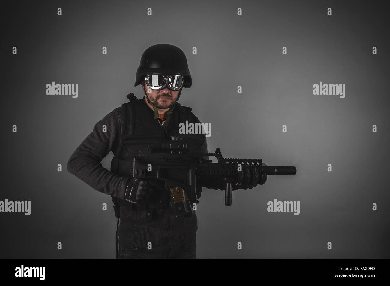 forces, airsoft player with gun, helmet and bulletproof vest on gray ...