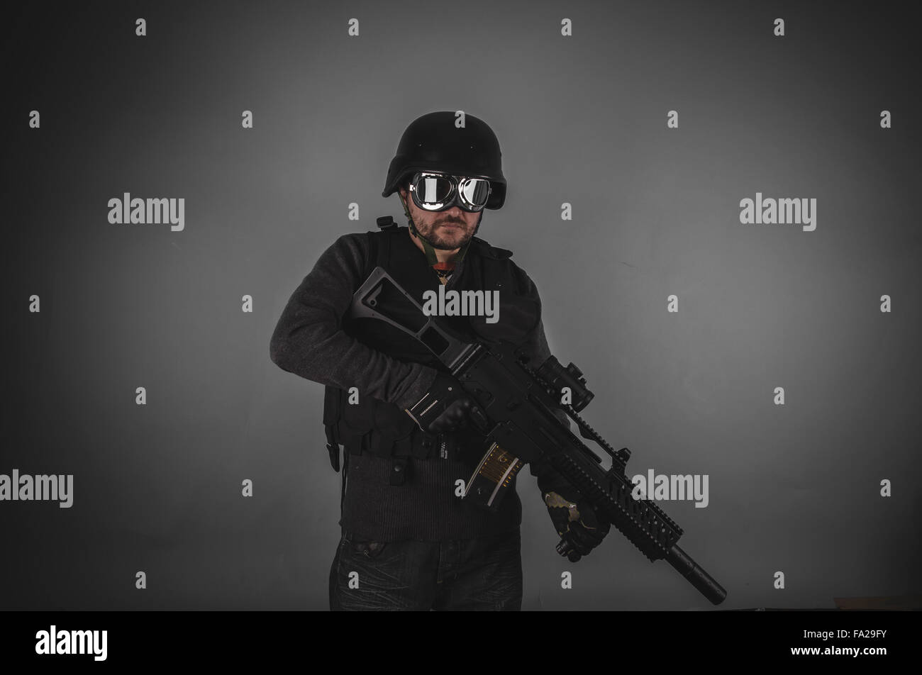 sniper, airsoft player with gun, helmet and bulletproof vest on gray ...