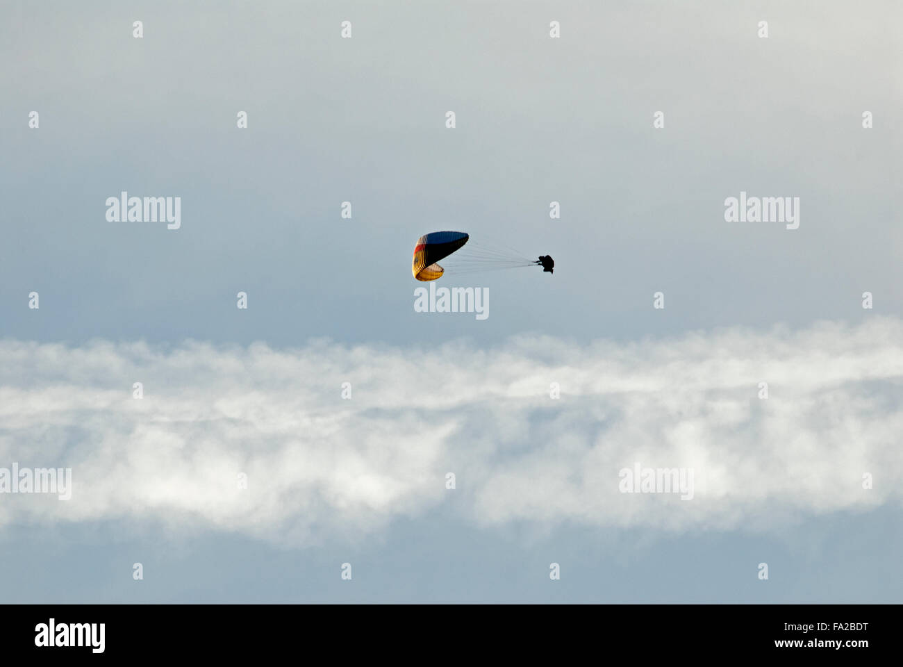 Paraglider pilot performing partial wingovers with vapor trail from jet ...