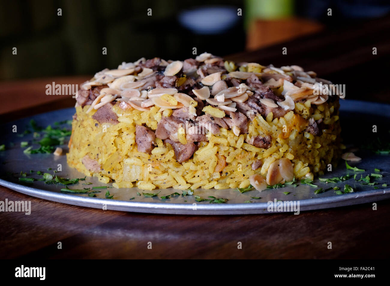 Traditional Maqluba served with crushed almonds. Maqluba or Maklube is ...