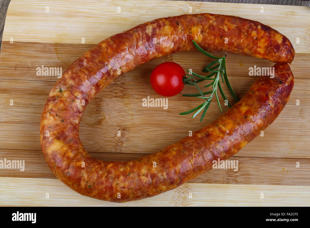 Sausage ring with rosemary and pepper on the wood background Stock ...