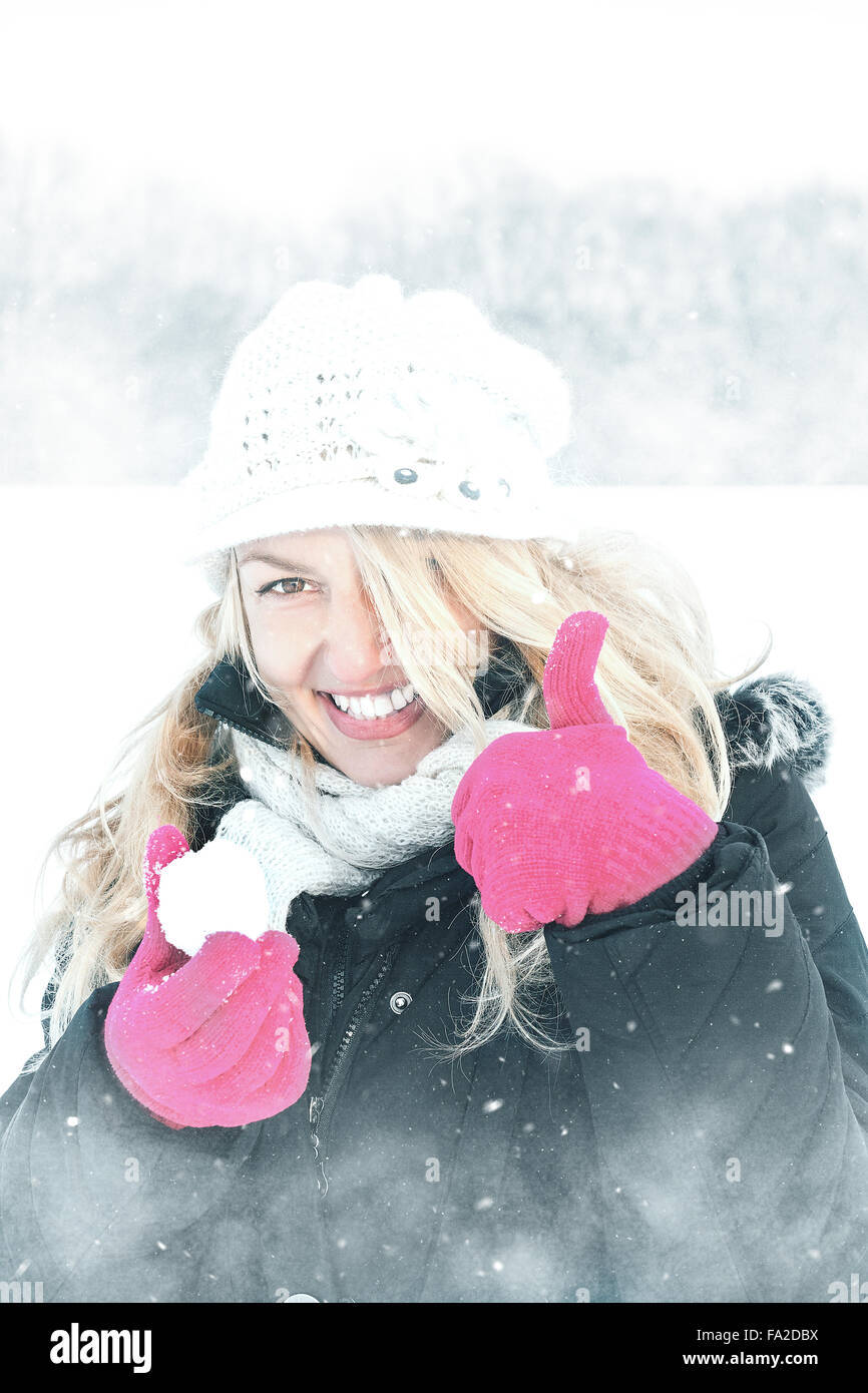 winter happy woman in snow holding snow ball in hand for snowballing ...