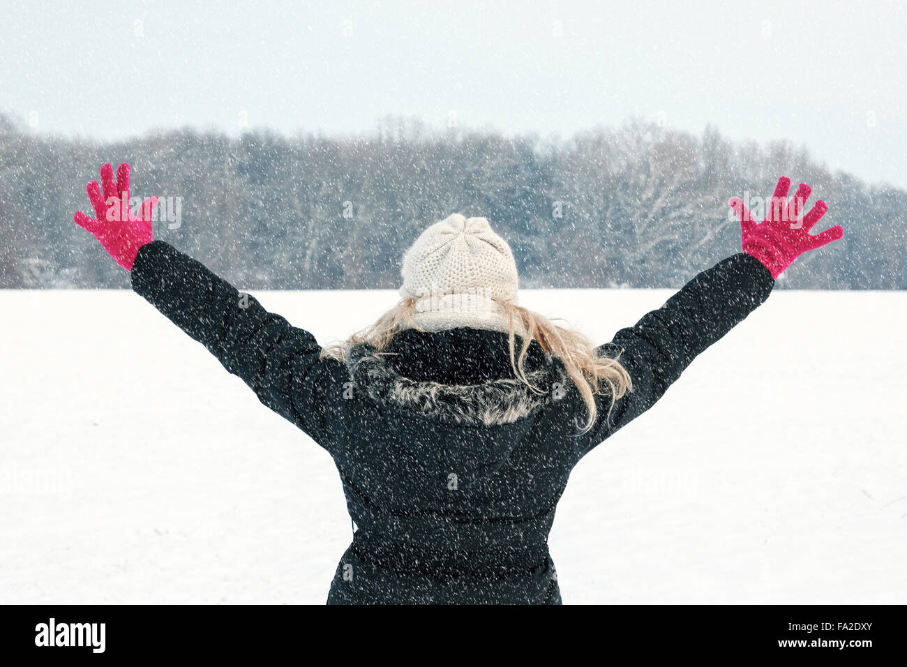 winter woman in snow showing her back and facing forest with hands ...
