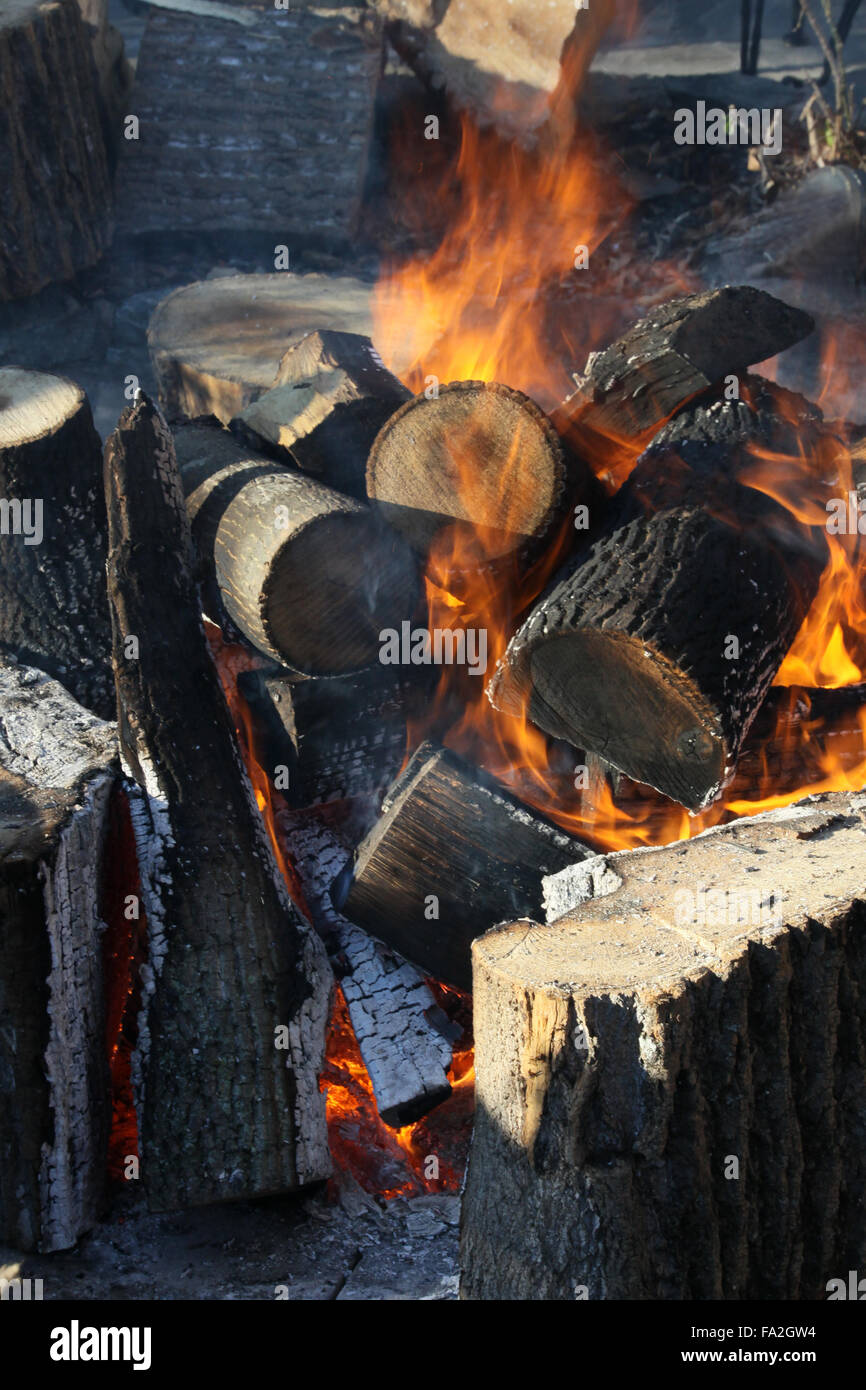 Logs burning in an open air fire place Stock Photo - Alamy