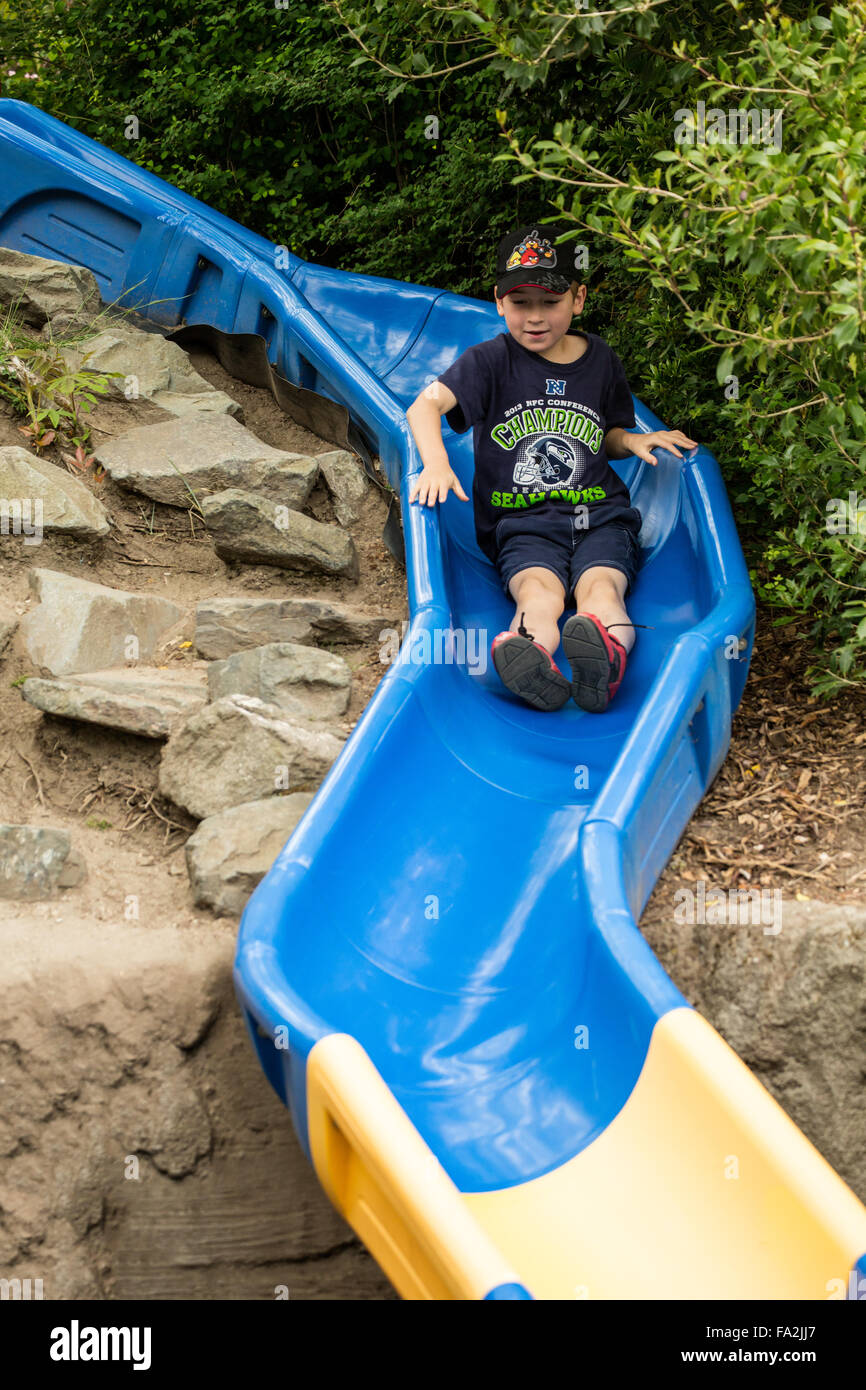 Seven year old boy going down a slide in Seattle, Washington, USA Stock ...
