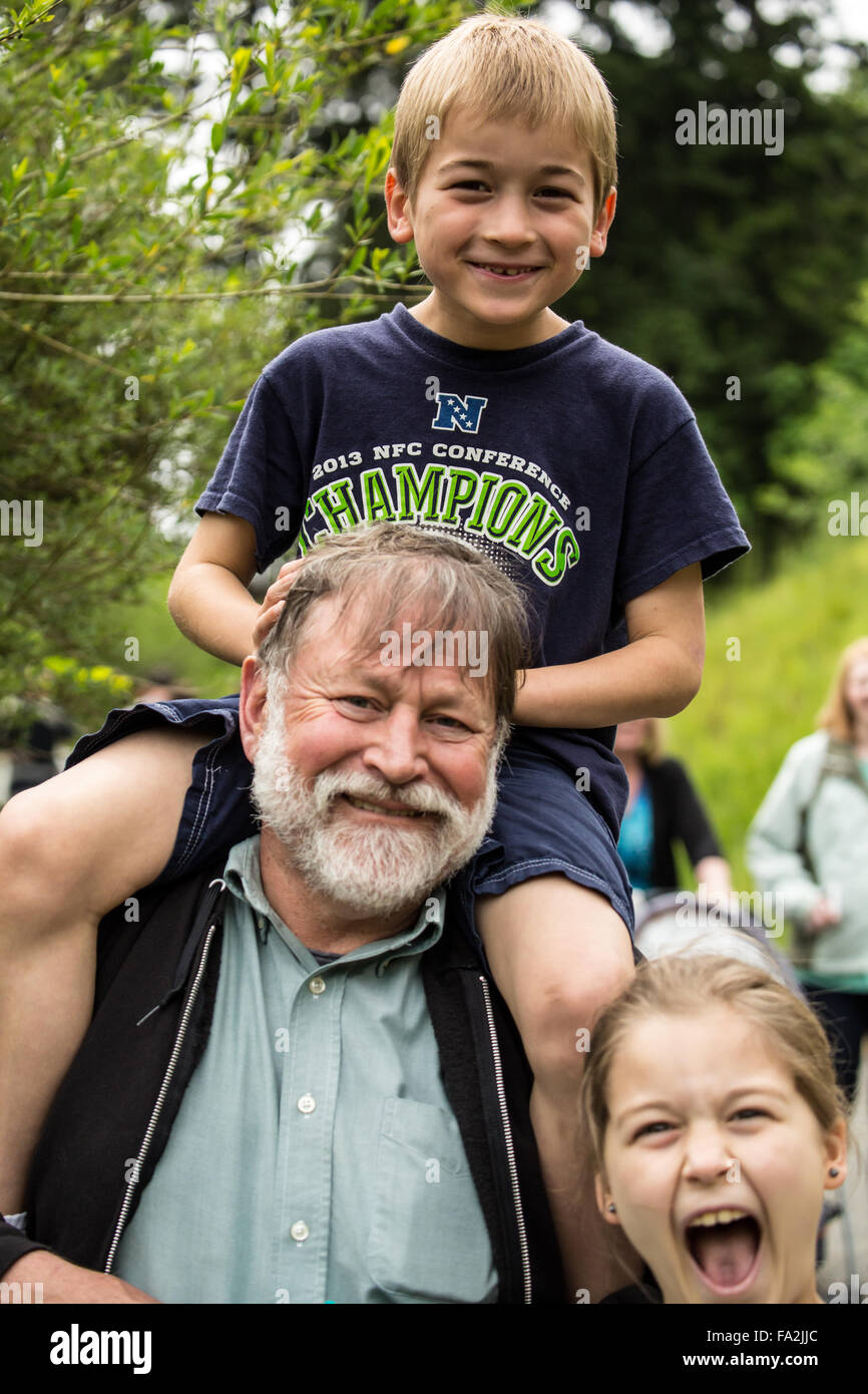 Seven year old boy getting a piggyback ride from his grandfather, with ...