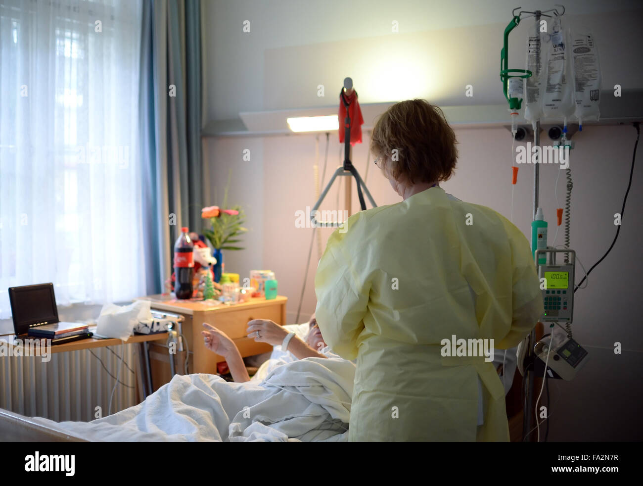 Berlin, Germany. 07th Dec, 2015. Hospital aide Andrea Dede treats a ...