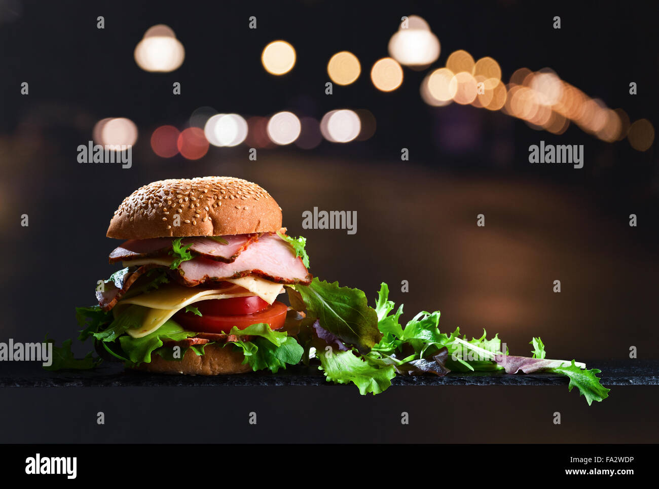 burger with ham and salad on a dark background Stock Photo - Alamy