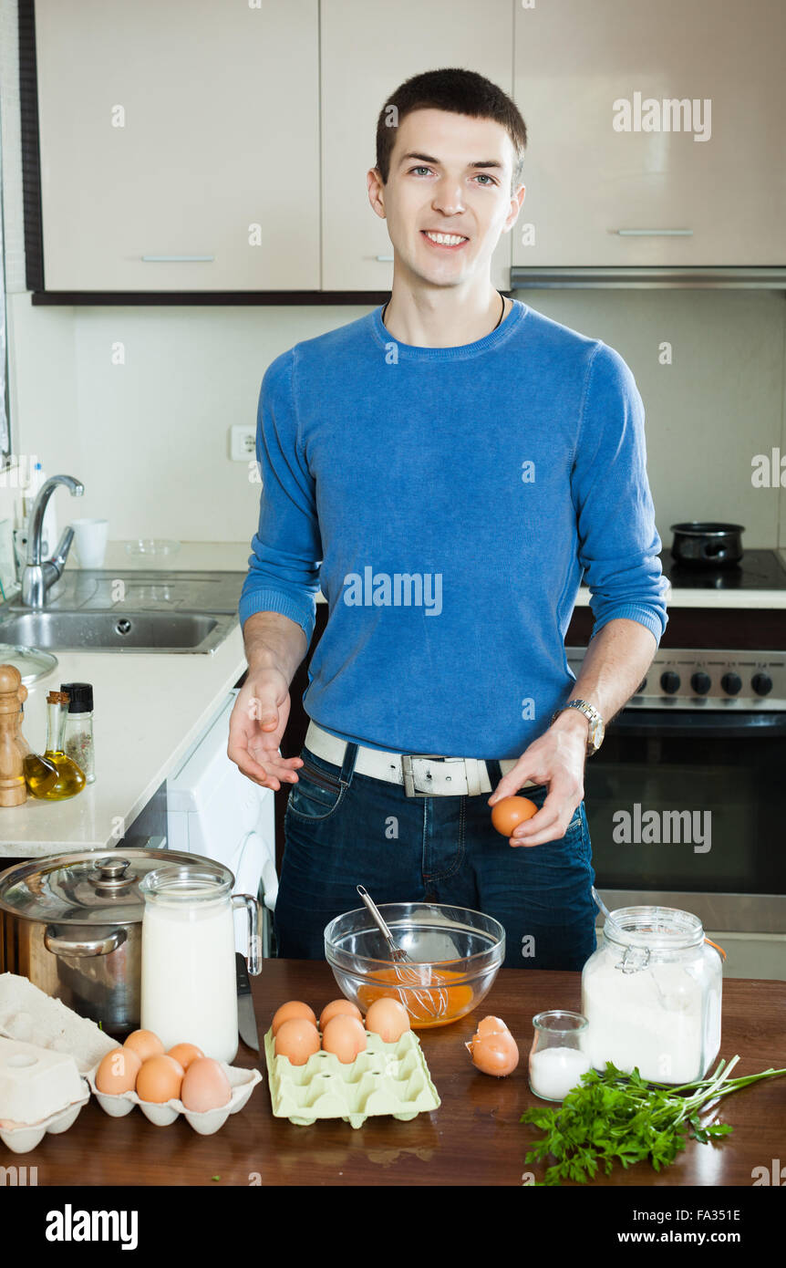 Guy cooking scrambled eggs in home kitchen Stock Photo - Alamy
