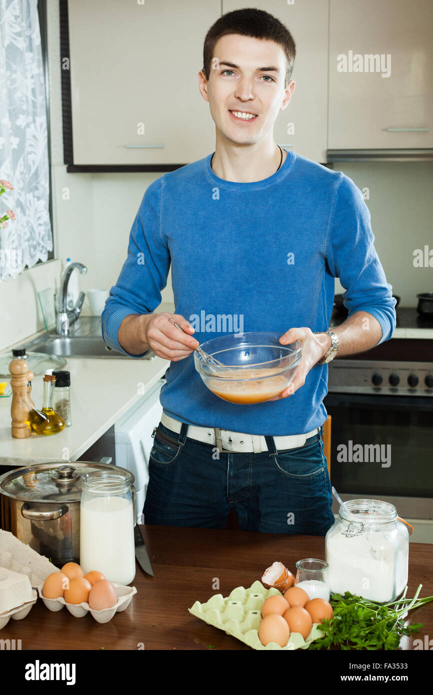 man cooking scrambled eggs in the kitchen Stock Photo - Alamy