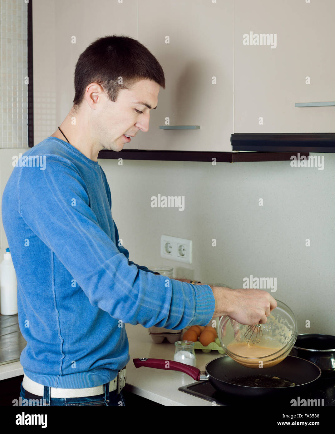 Man cooking scrambled eggs in pan at home kitchen Stock Photo - Alamy