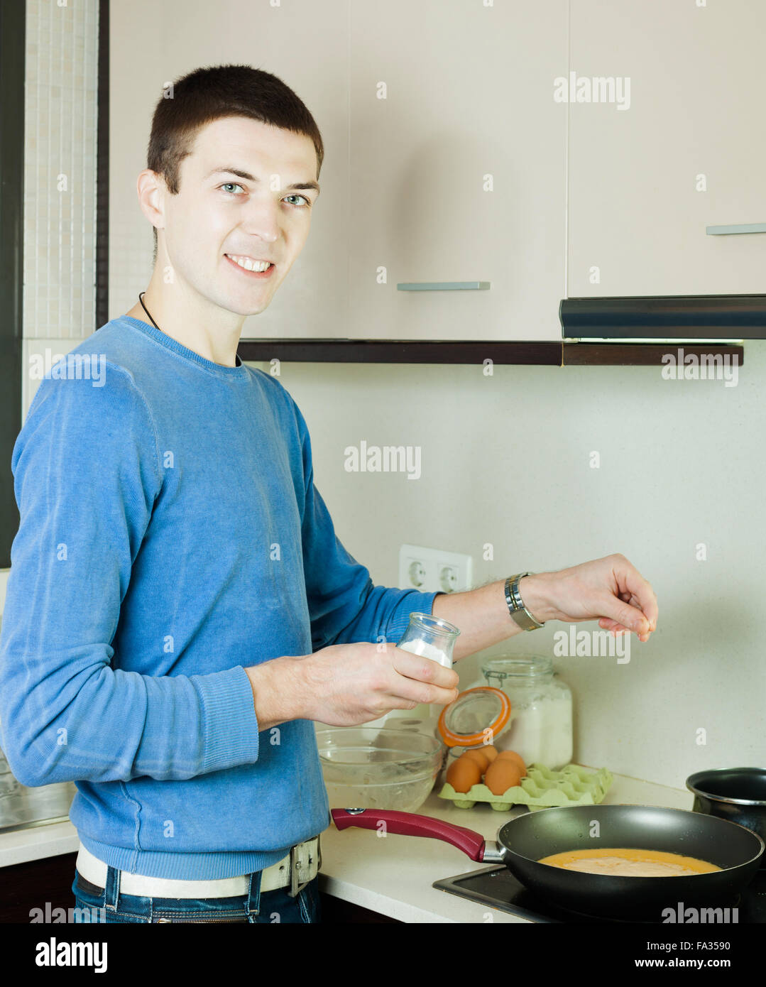 man making scrambled eggs in frying pan at home kitchen Stock Photo - Alamy