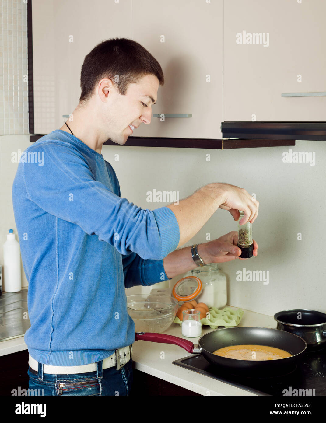 Smiling man cooking omlet in kitchen Stock Photo - Alamy