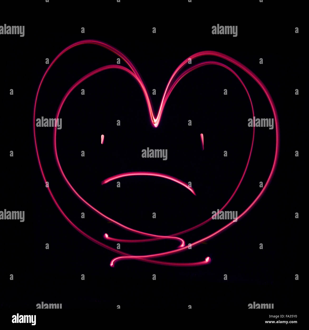 Sad heart generated by a beam of red light, with long exposure Stock ...