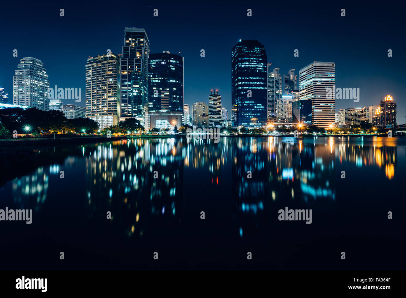 Modern skyscrapers and Lake Rajada at night, at Benjakiti Park, in ...