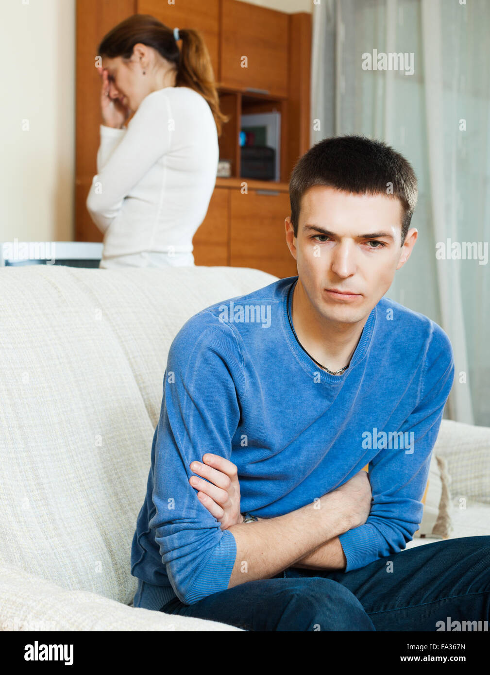 Family conflict. Young couple after quarrel in living room at home ...
