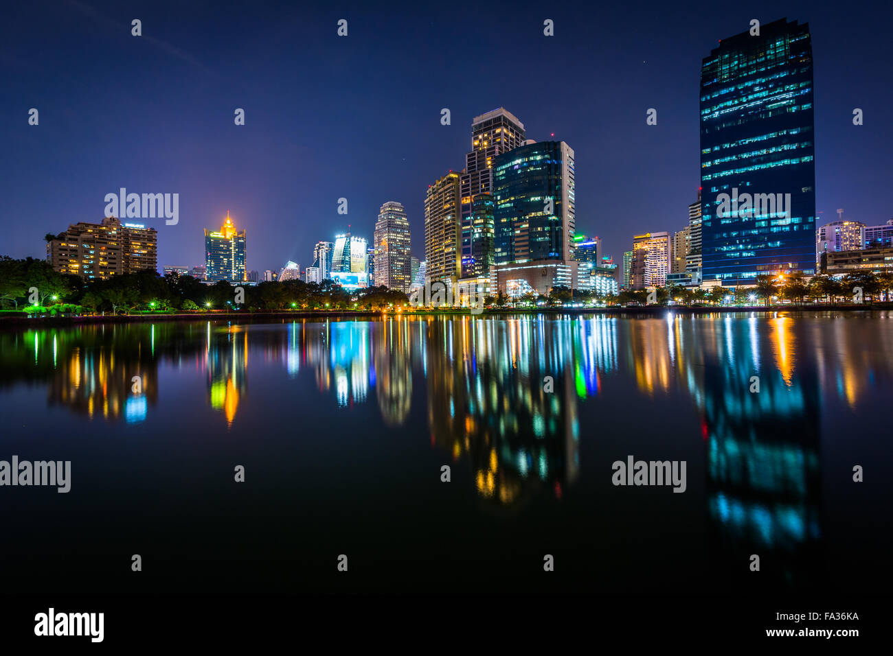 Modern skyscrapers and Lake Rajada at night, at Benjakiti Park, in ...