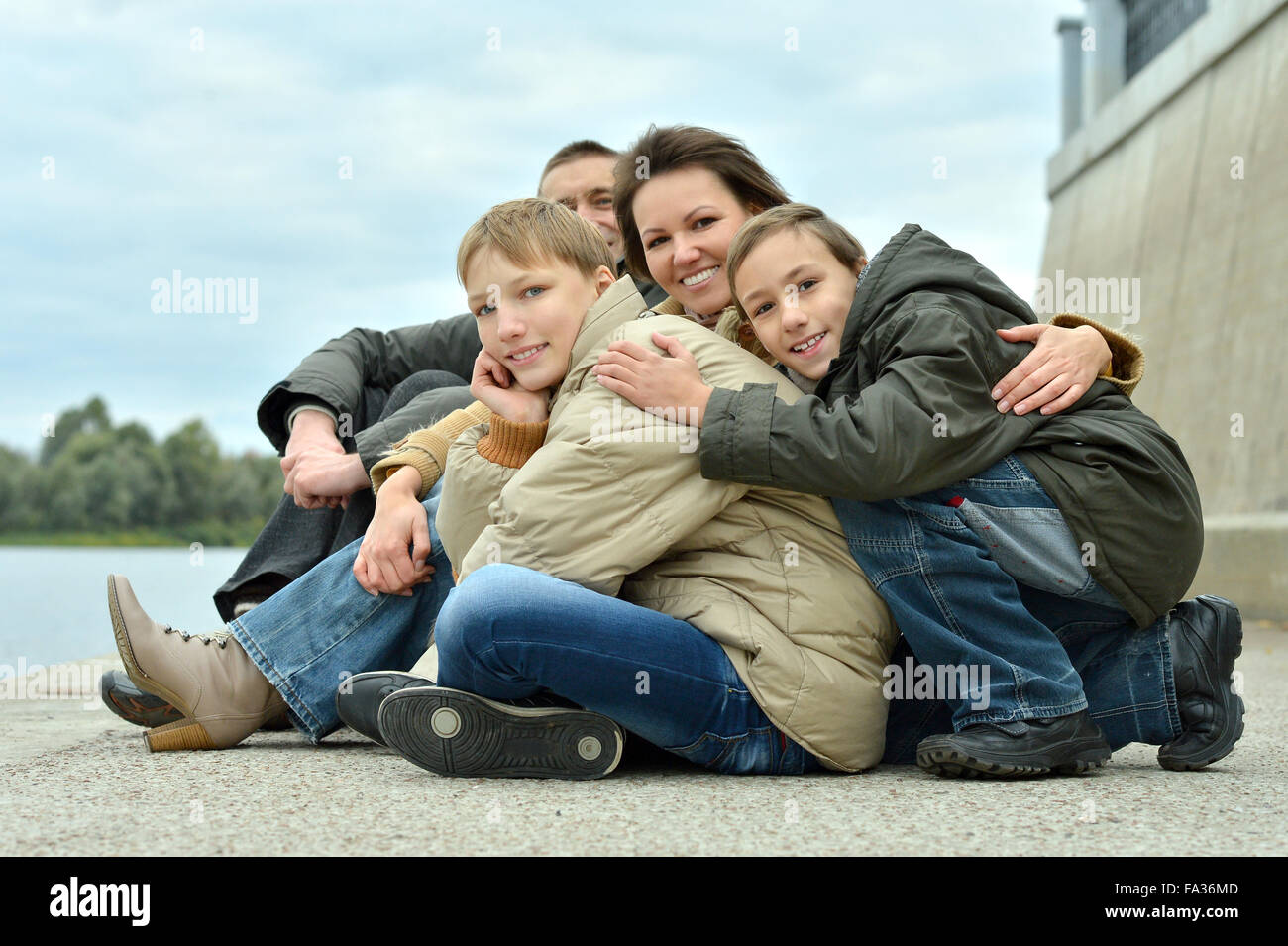Family of four sitting Stock Photo - Alamy