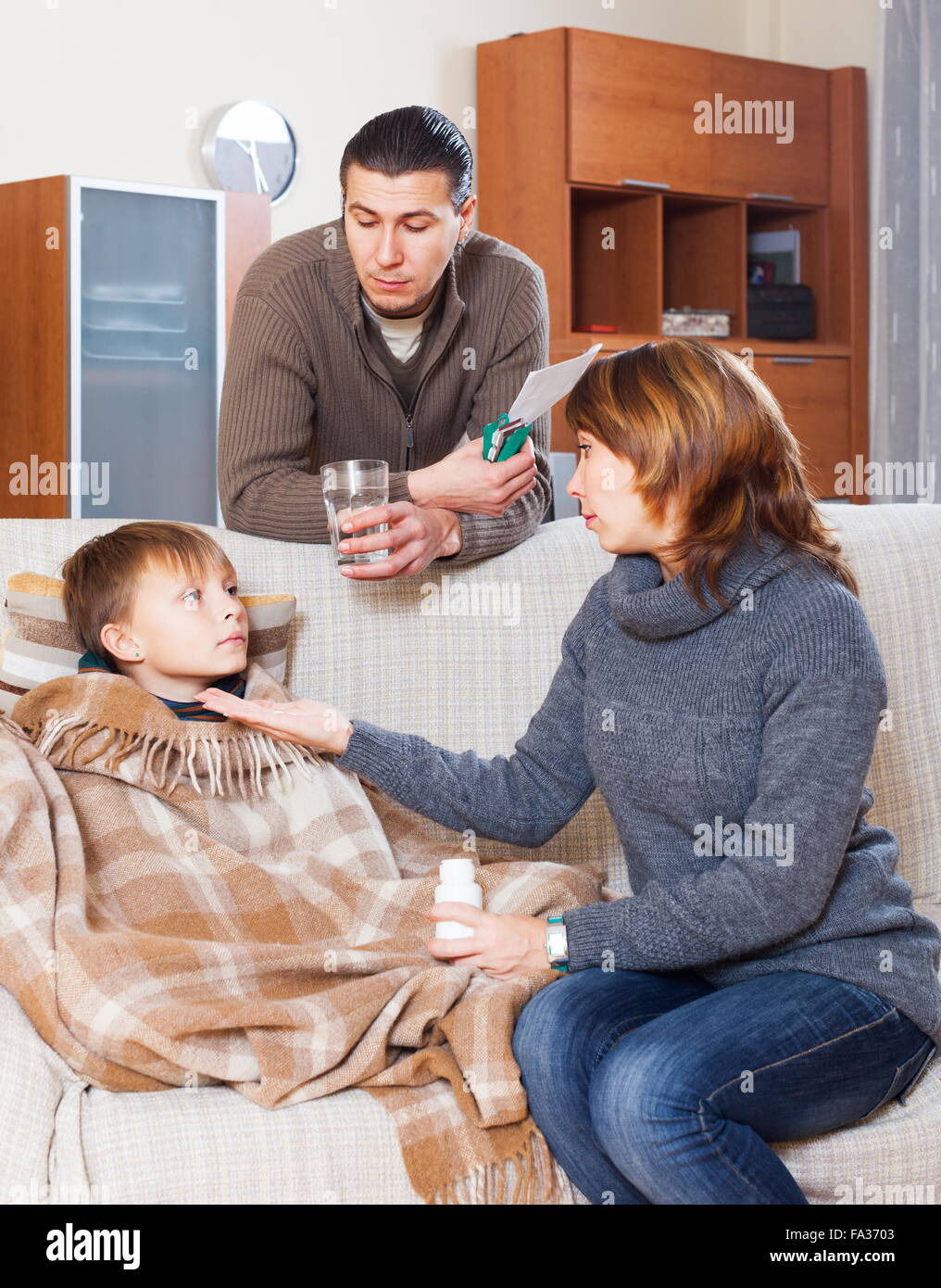 Loving parents giving tablets to boy at home Stock Photo - Alamy