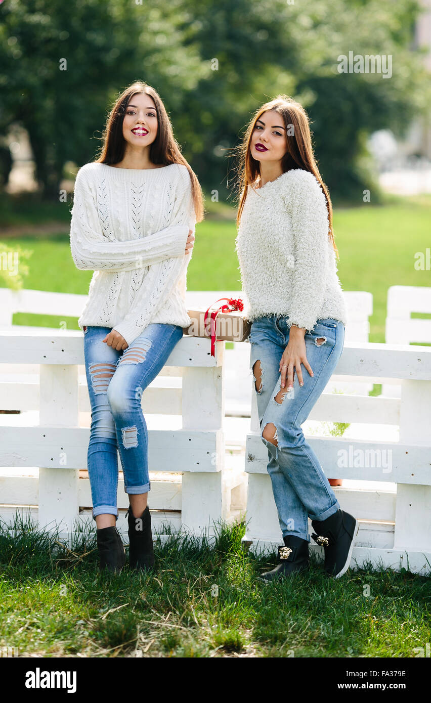 Two girls lean bench Stock Photo - Alamy