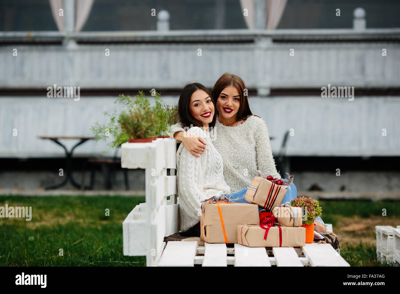 Two beautiful girls sitting on a bench Stock Photo - Alamy