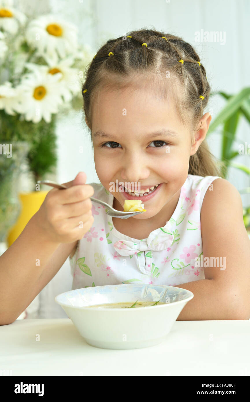 Beautiful little girl with soup Stock Photo - Alamy