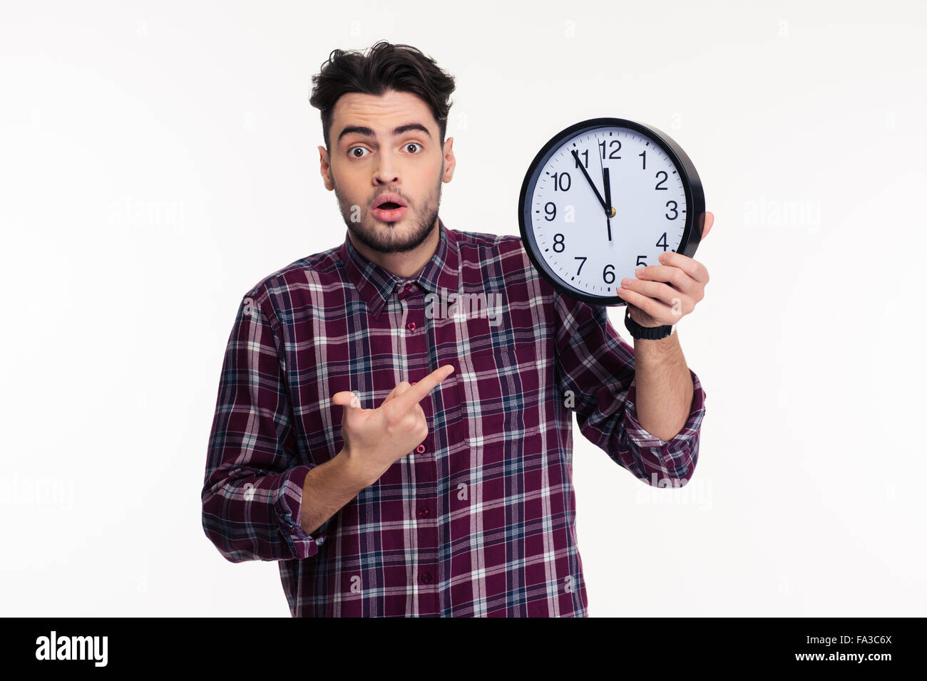 Portrait of a young casual man holding wall clock isolated on a white ...
