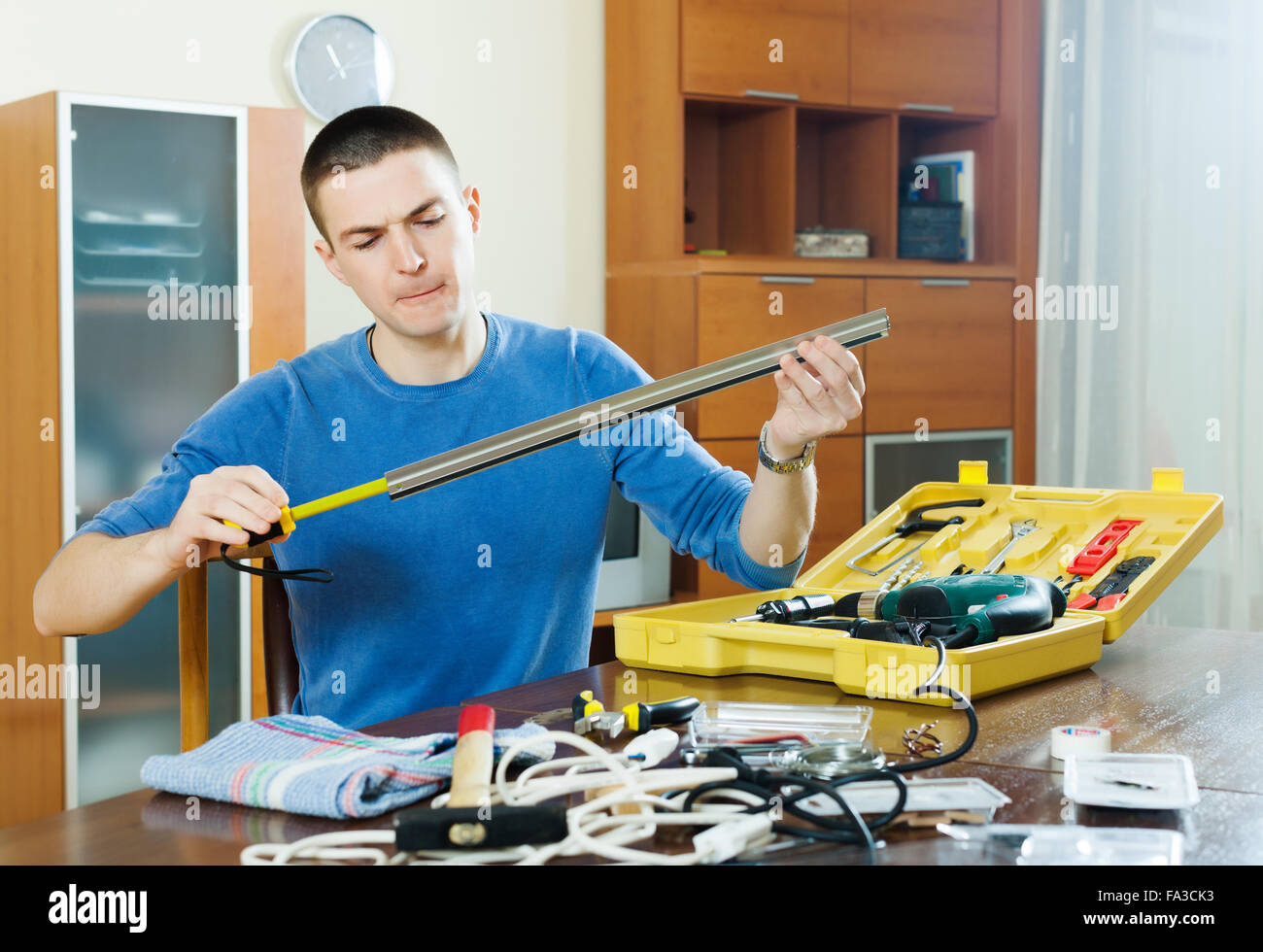 Guy measuring something with tape measure at table Stock Photo - Alamy