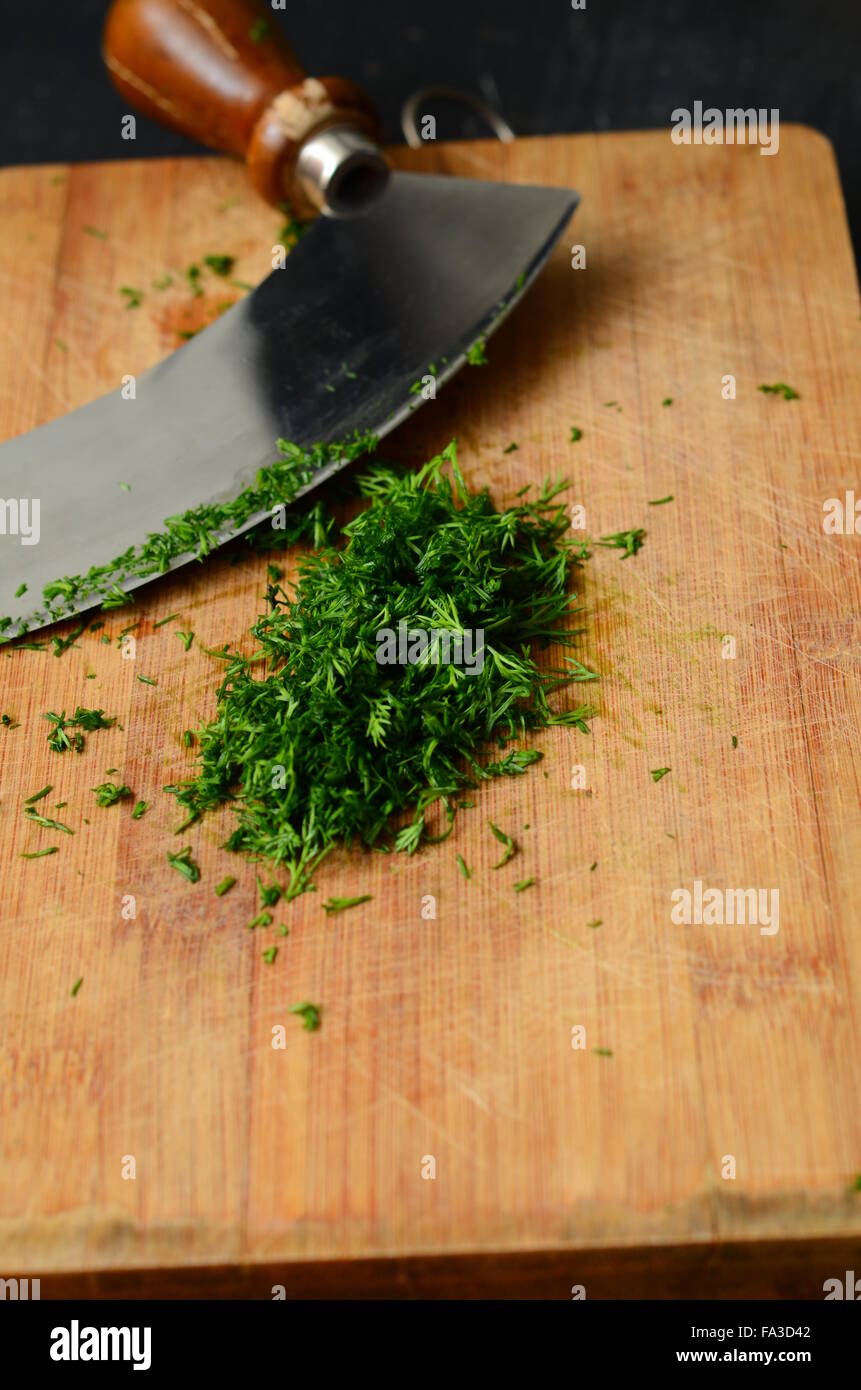 Chopping fresh dill with a curved mezzaluna knife Stock Photo - Alamy