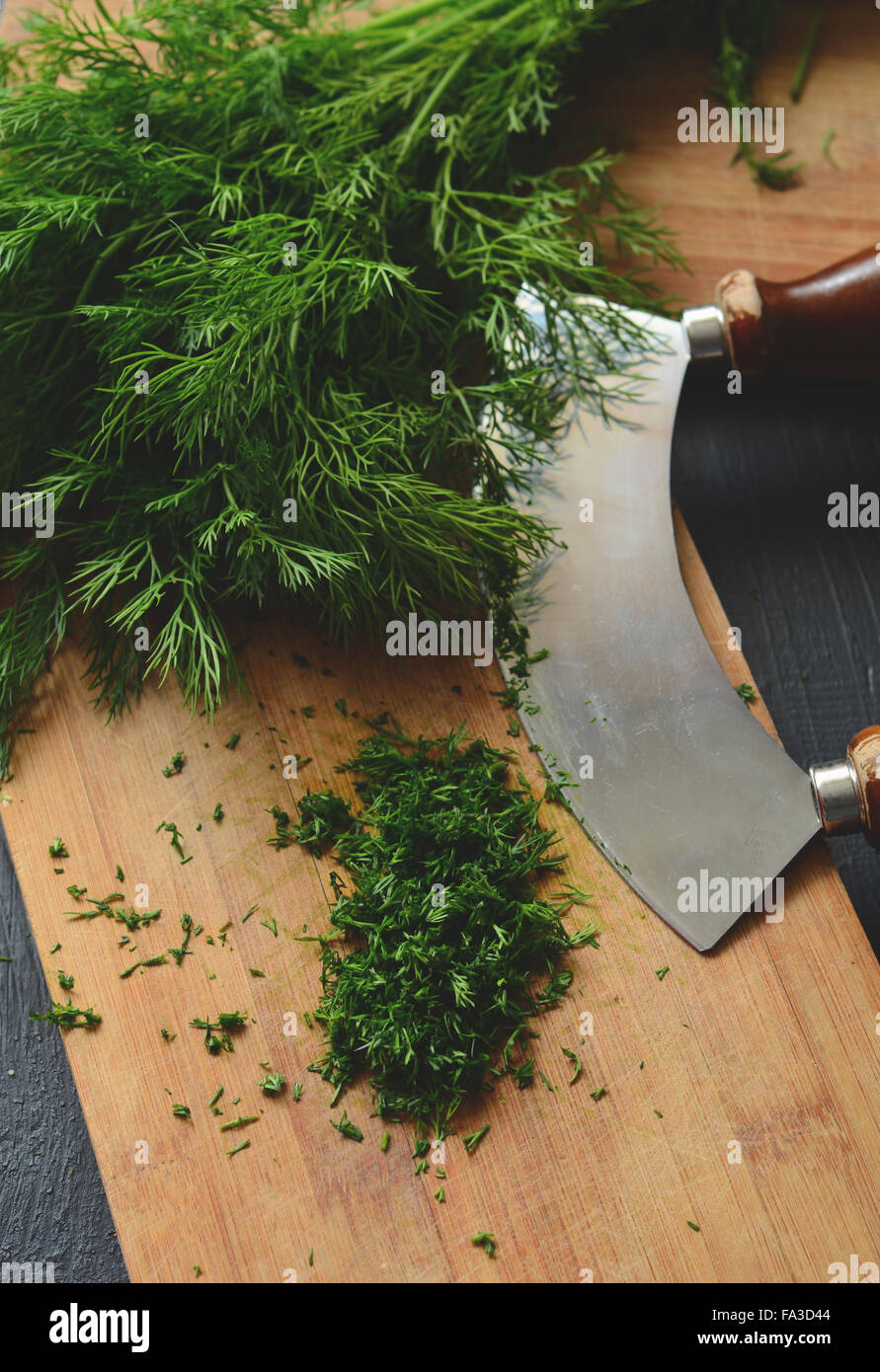 Chopping fresh dill with a curved mezzaluna knife Stock Photo - Alamy