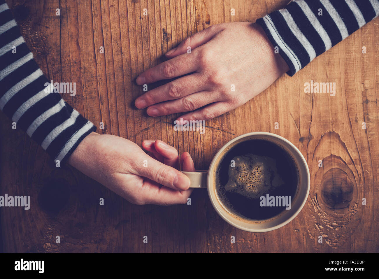 Lonely woman drinking coffee in the morning, top view of female hands ...