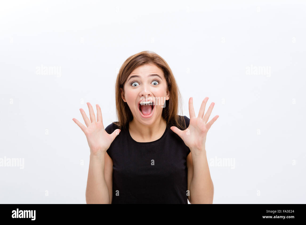 Scared screaming young female in black top over white background Stock ...