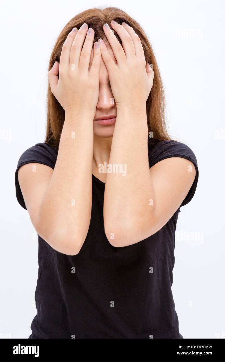 Stressed desperate young woman covered eyes by hands over white ...
