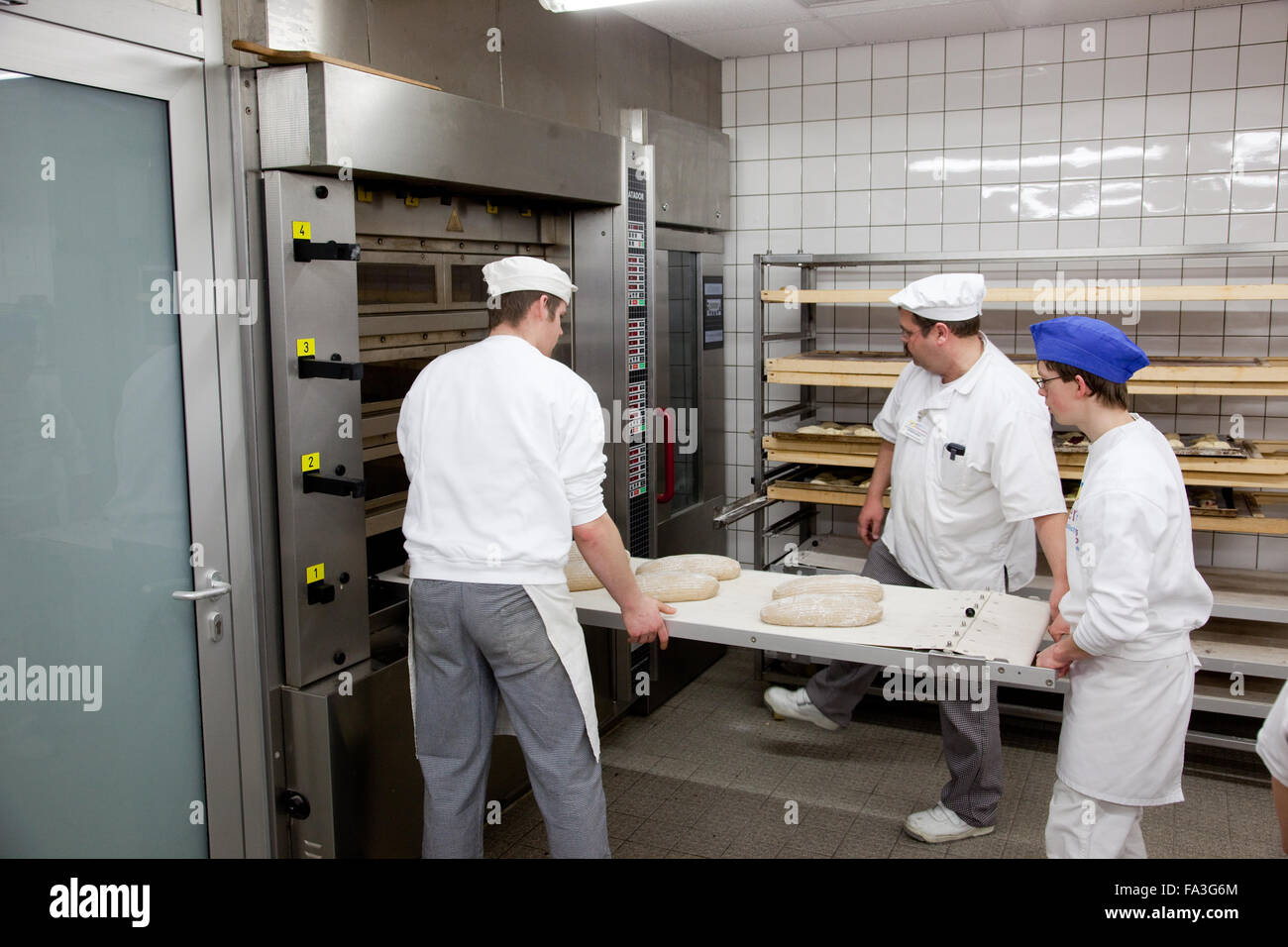 Master baker explains the oven to apprentices Stock Photo - Alamy