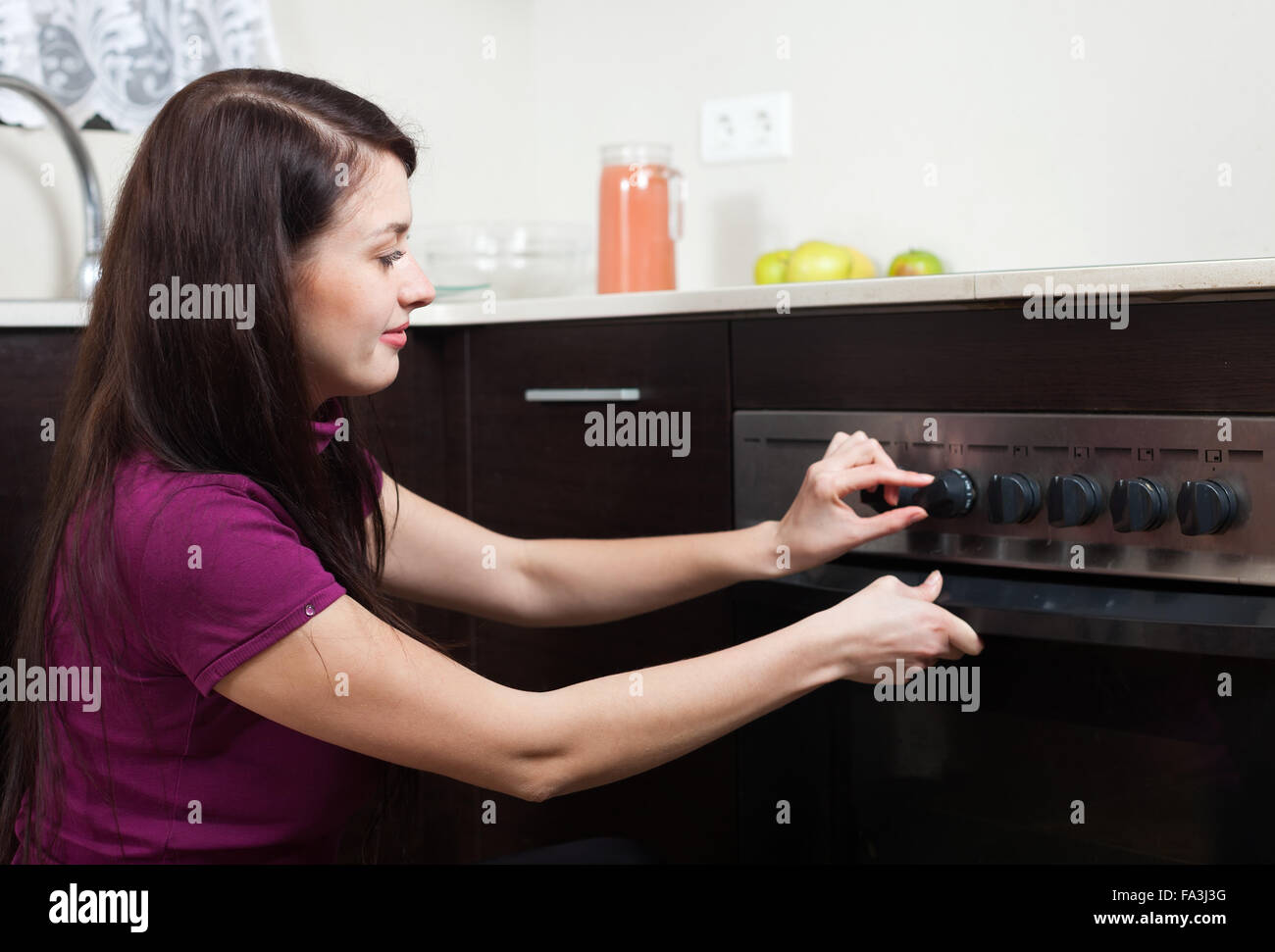 Woman cooking something in the oven in kitchen Stock Photo - Alamy