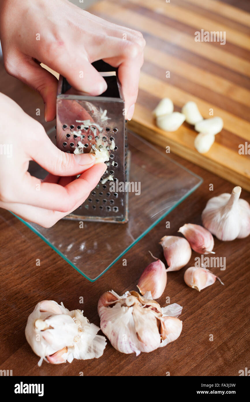 Closeup of hands grating garlic Stock Photo - Alamy