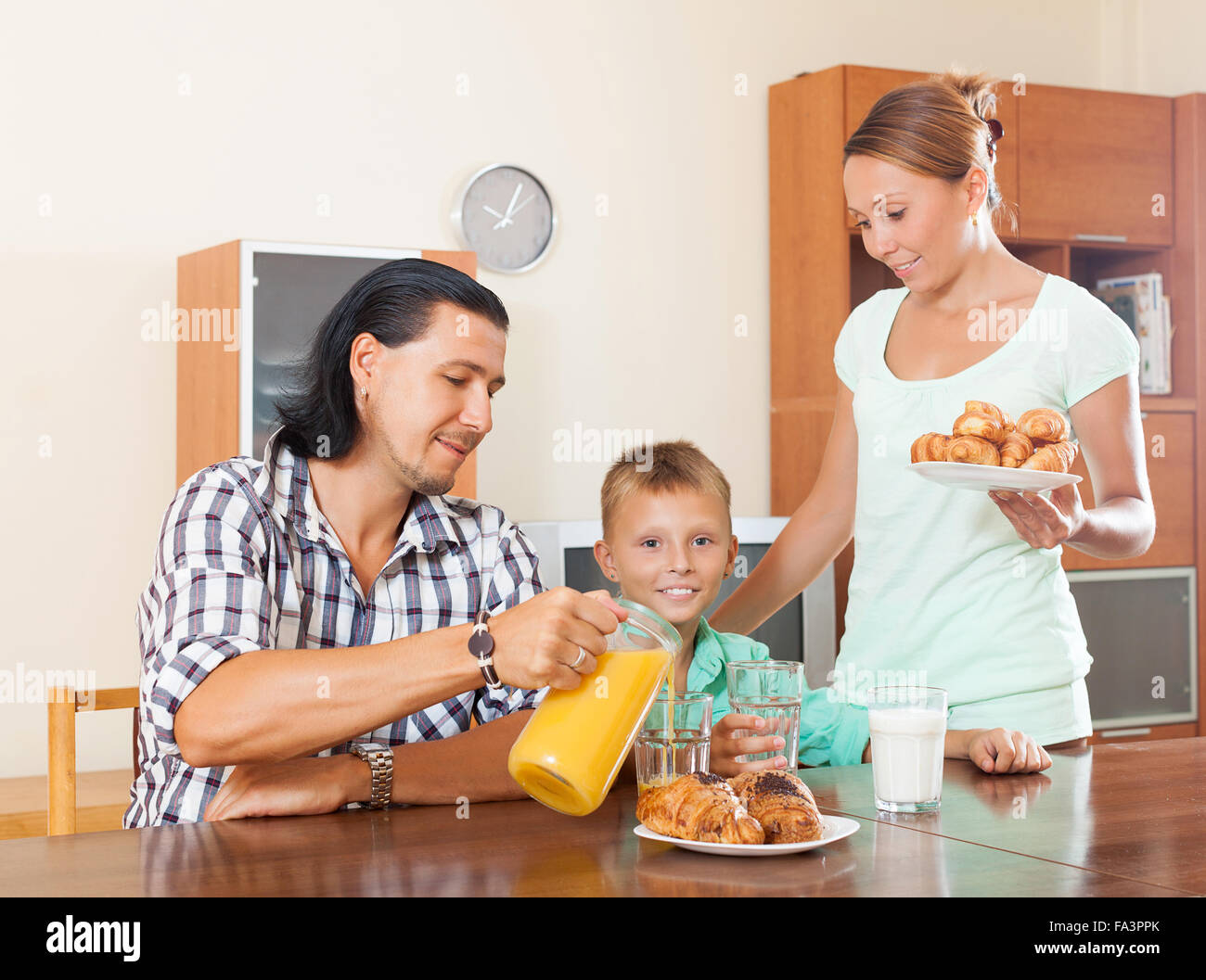 Happy family of three having breakfast at home Stock Photo - Alamy