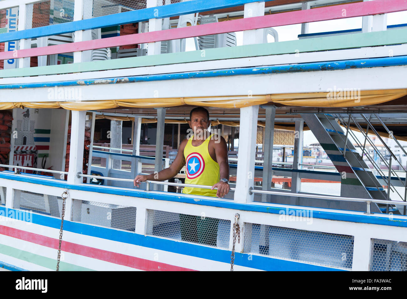 Man standing on a traditional double-decked wooden Amazon passenger ...
