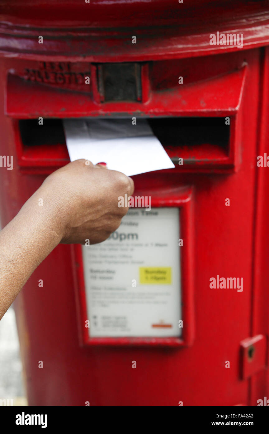 Close up of a letter being posted in to a post box Stock Photo - Alamy