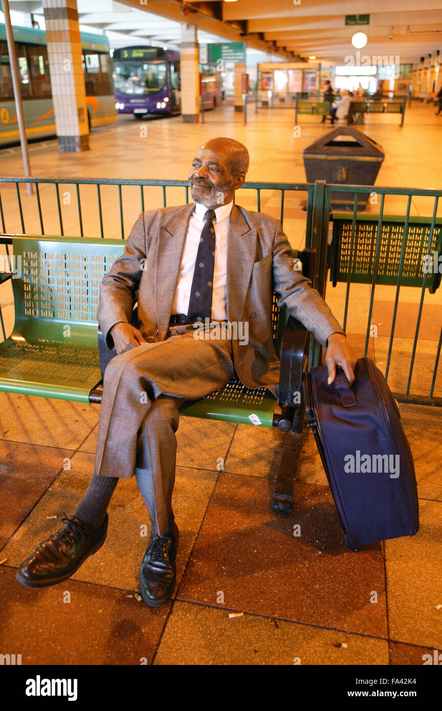Man waiting for a bus at the bus station Stock Photo - Alamy
