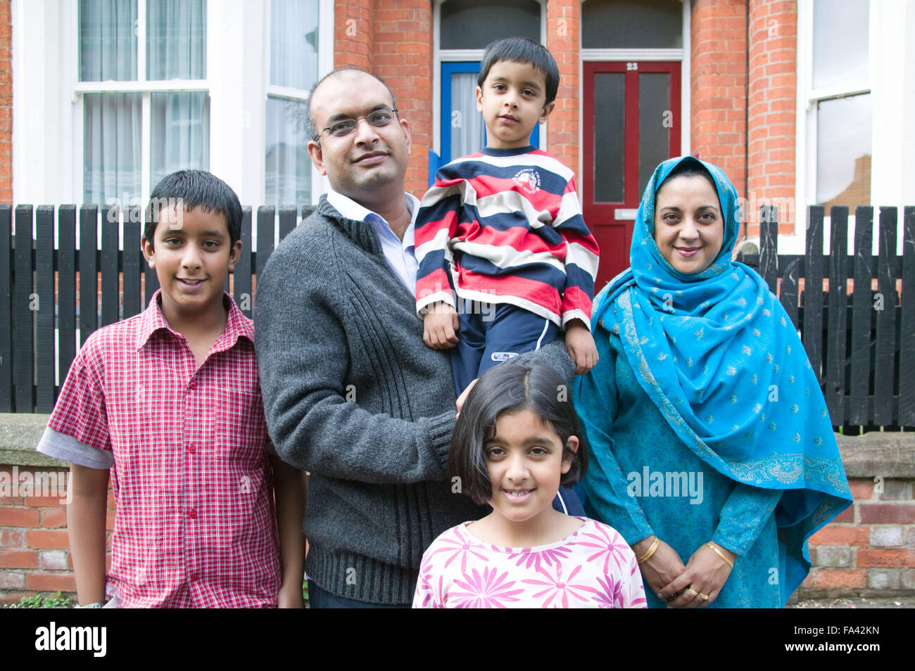 Young family standing outside the front door to their home Stock Photo ...