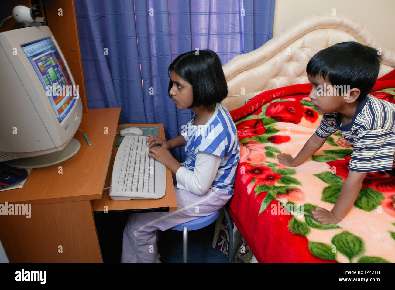 Brother and sister playing on the computer in bedroom Stock Photo - Alamy