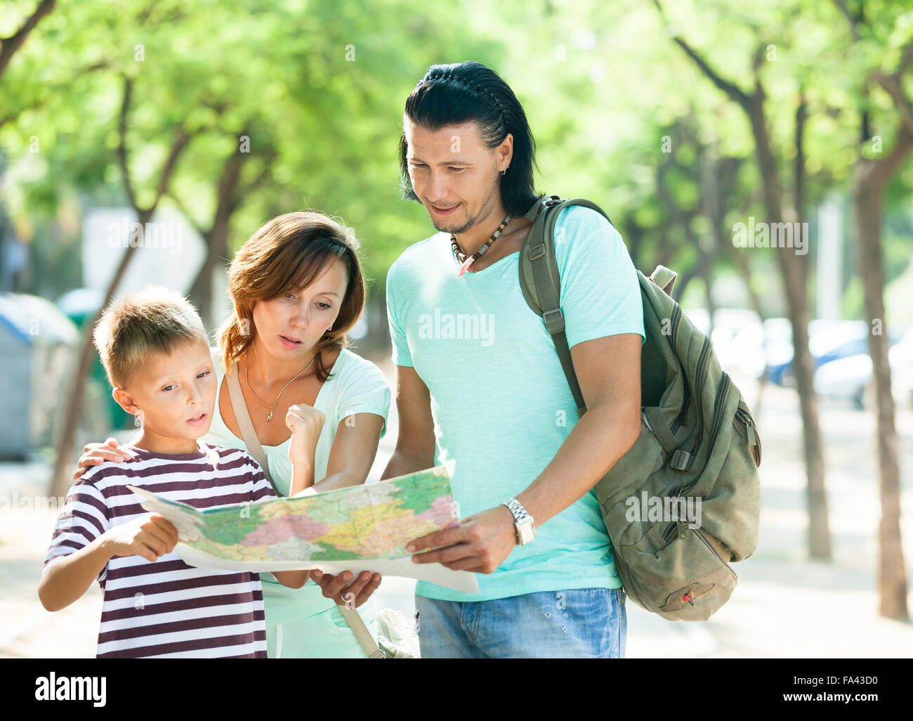 Tourist family looking at the map at city street Stock Photo - Alamy